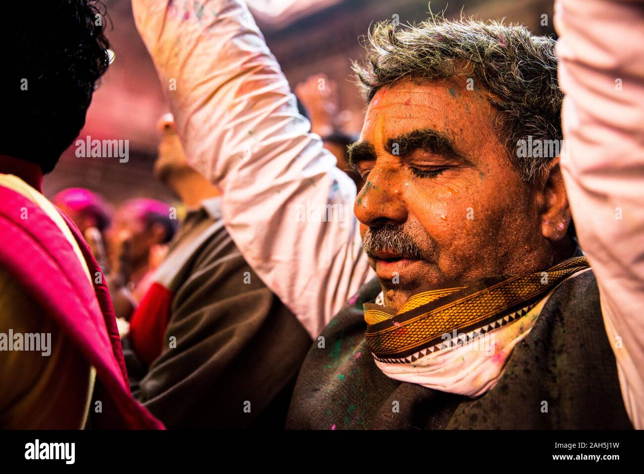 Man raising his arms in devotion during Holi celebrations inside Bankey ...