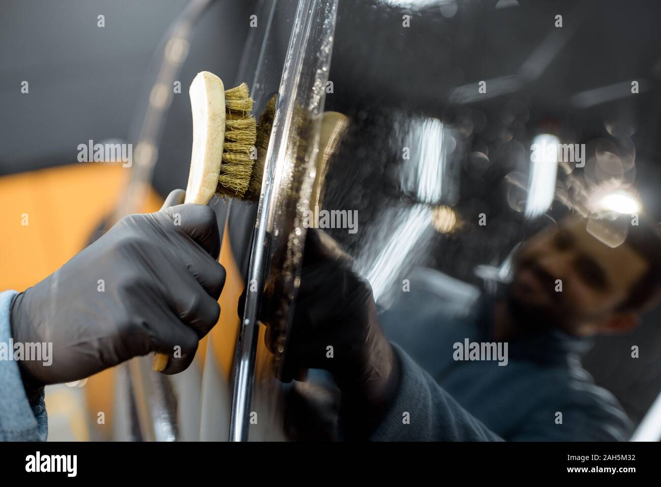 Scratching car body with metal brush to demonstrate the stability of ...