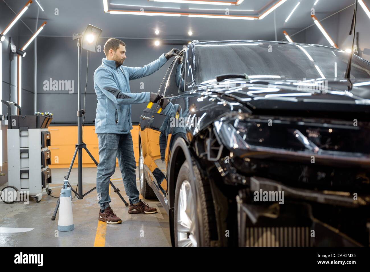 Car service worker sticking anti-gravel film on a window frame for ...