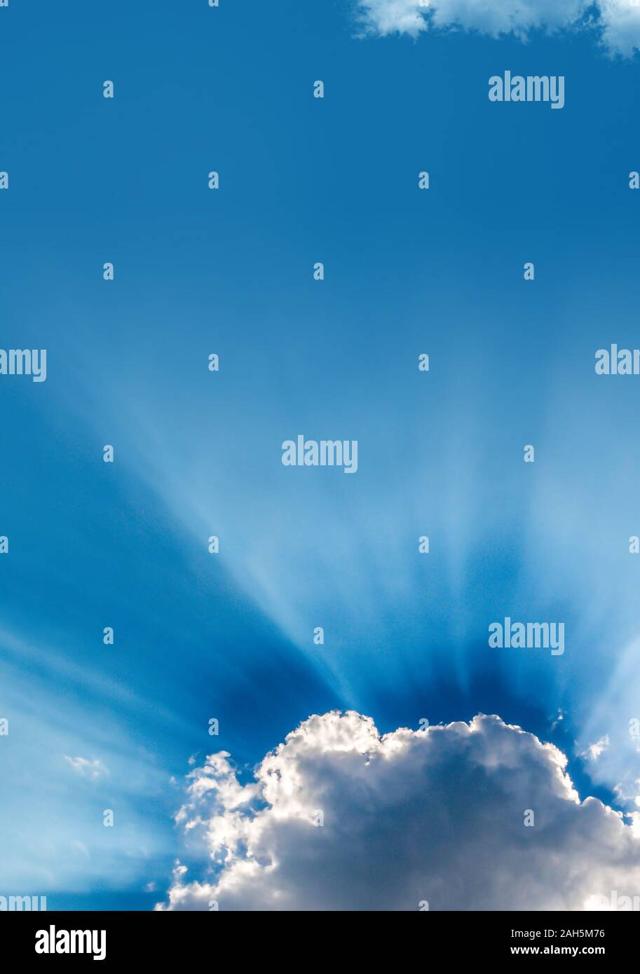 Sun rays bursting through clouds in a blue sky Stock Photo - Alamy