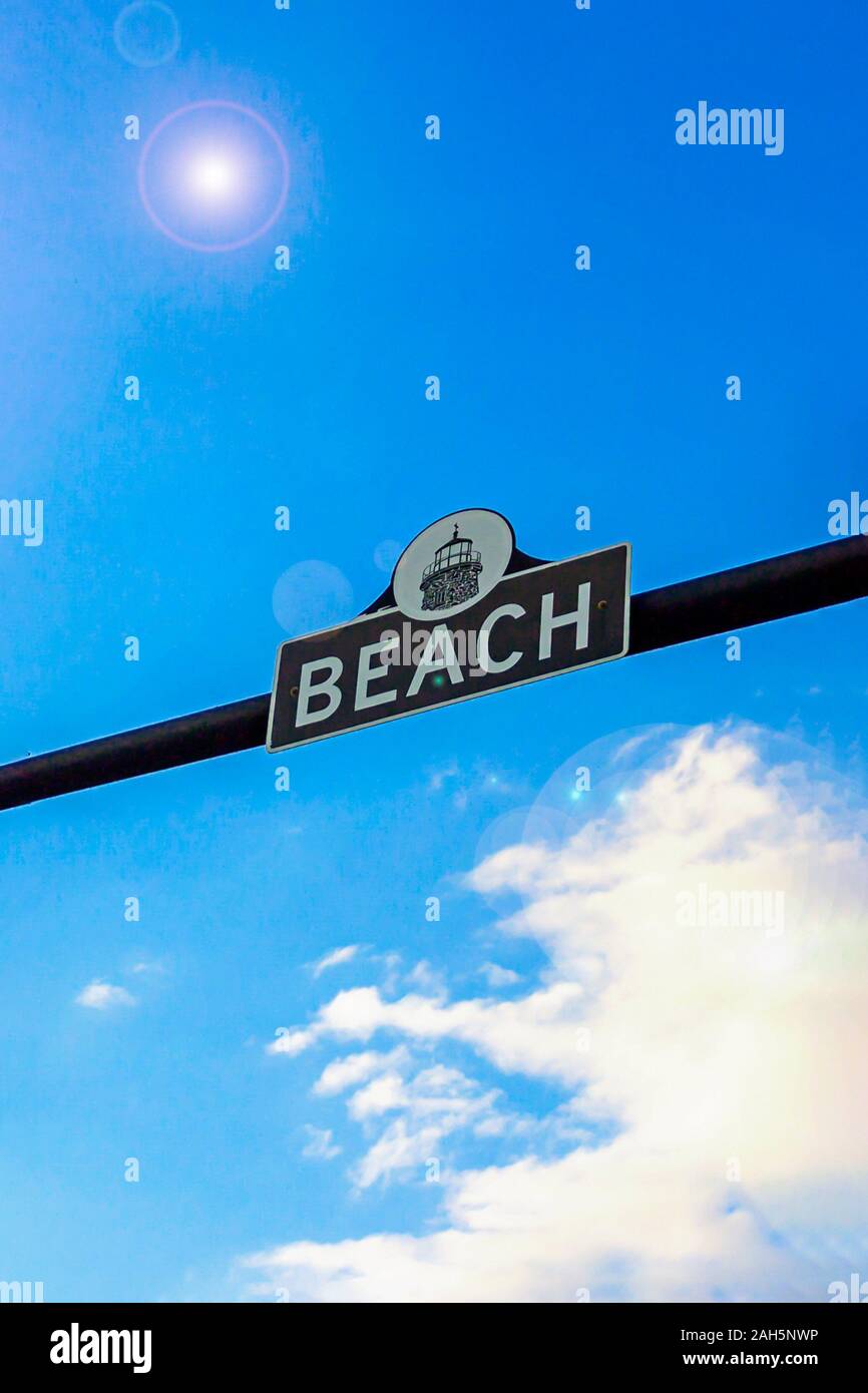 Street sign BEACH and blue sky with sun glare Stock Photo - Alamy