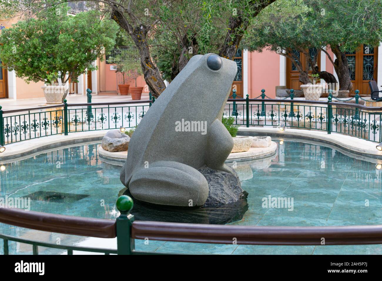 Kefalonia, Greece - August 23 2019: Frog statue in a small pond in ...