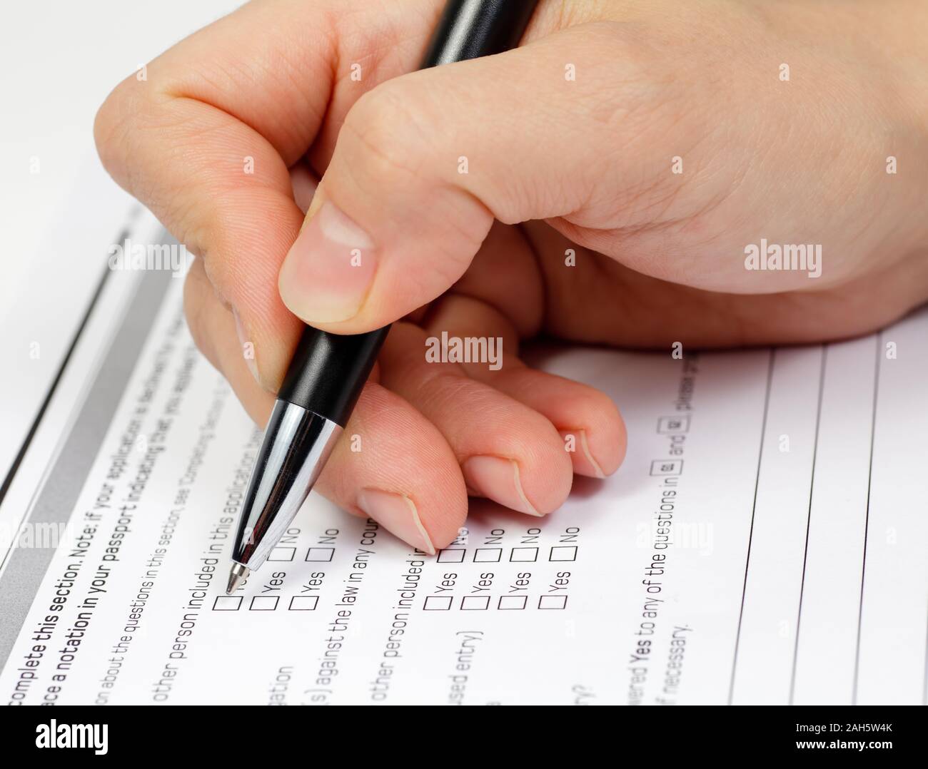 Hand with pen over blank check boxes in application form Stock Photo ...