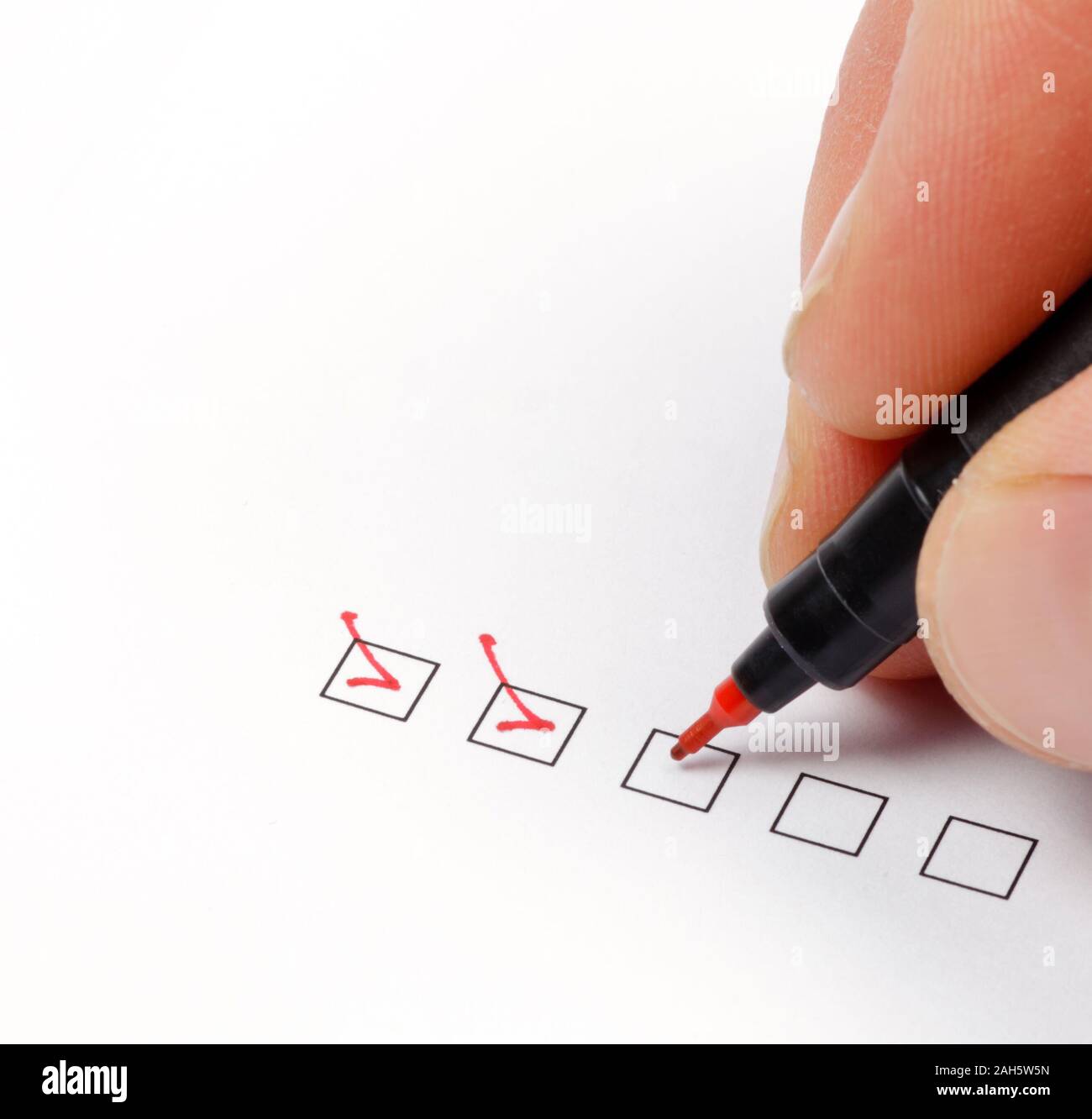 Hand with red pen marking a check box Stock Photo - Alamy