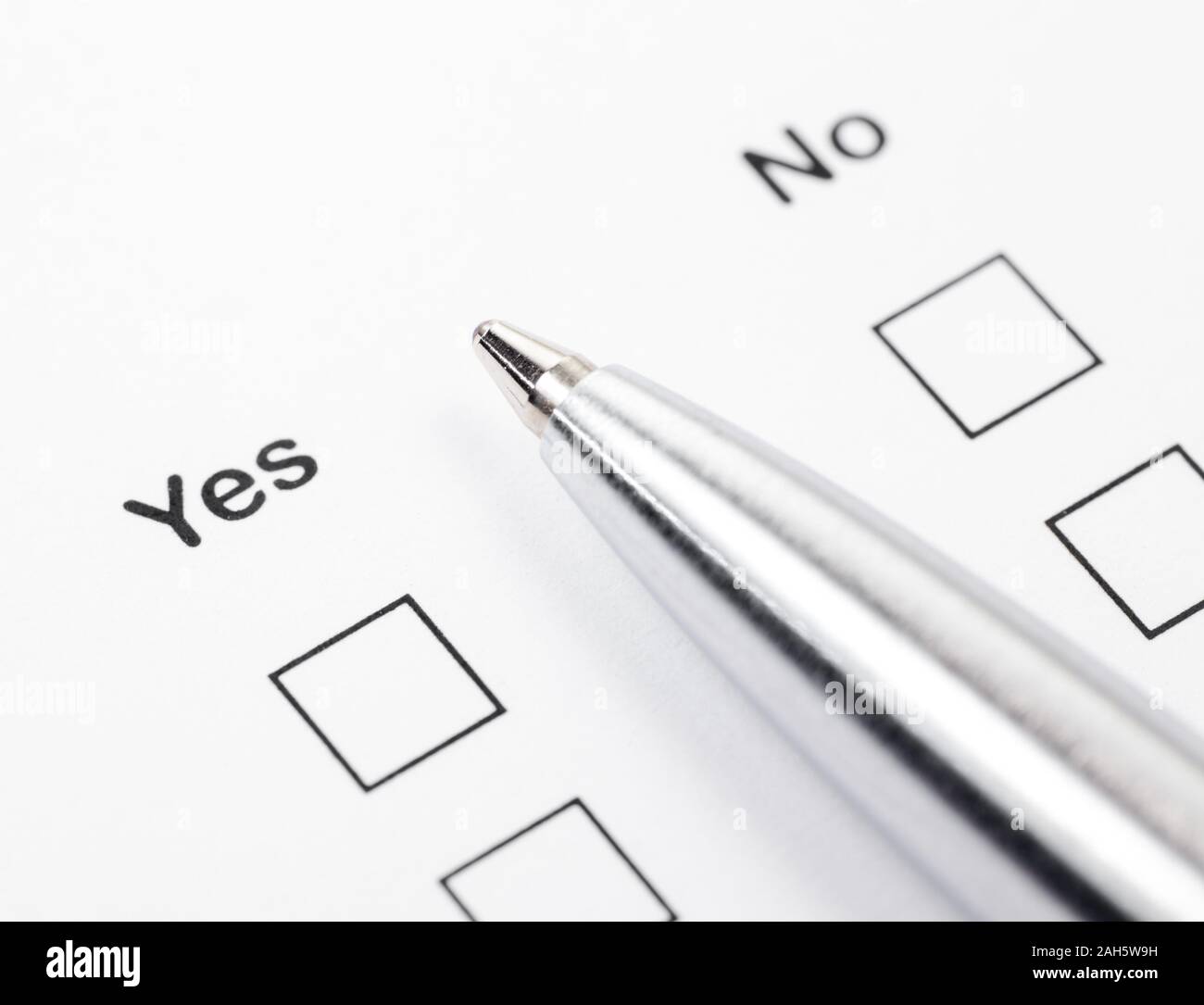Close up shot of ballpoint between unfilled tick boxes Yes and No Stock ...