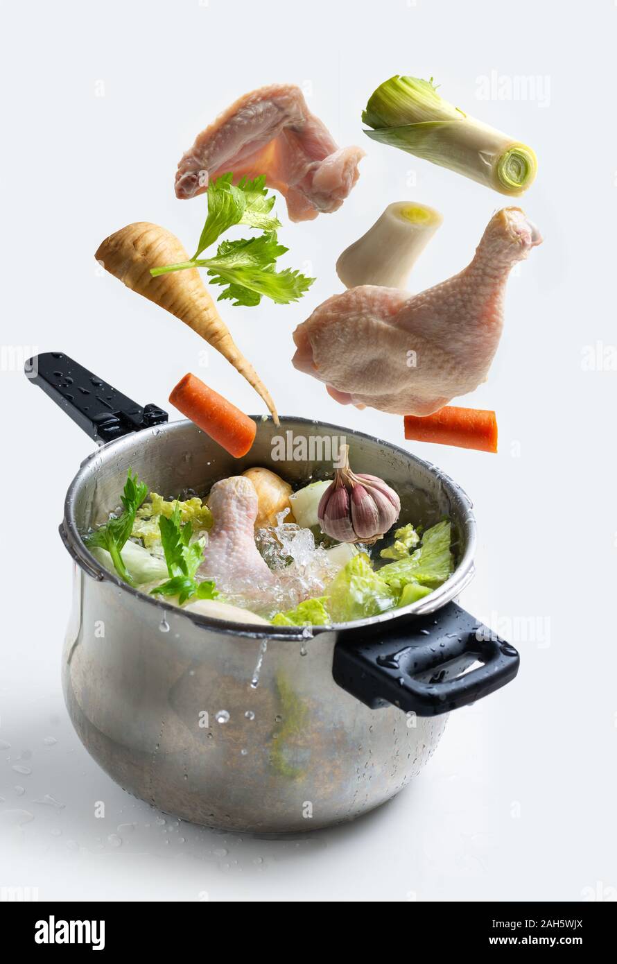 express pot with chicken stock and vegetables flying isolated white ...