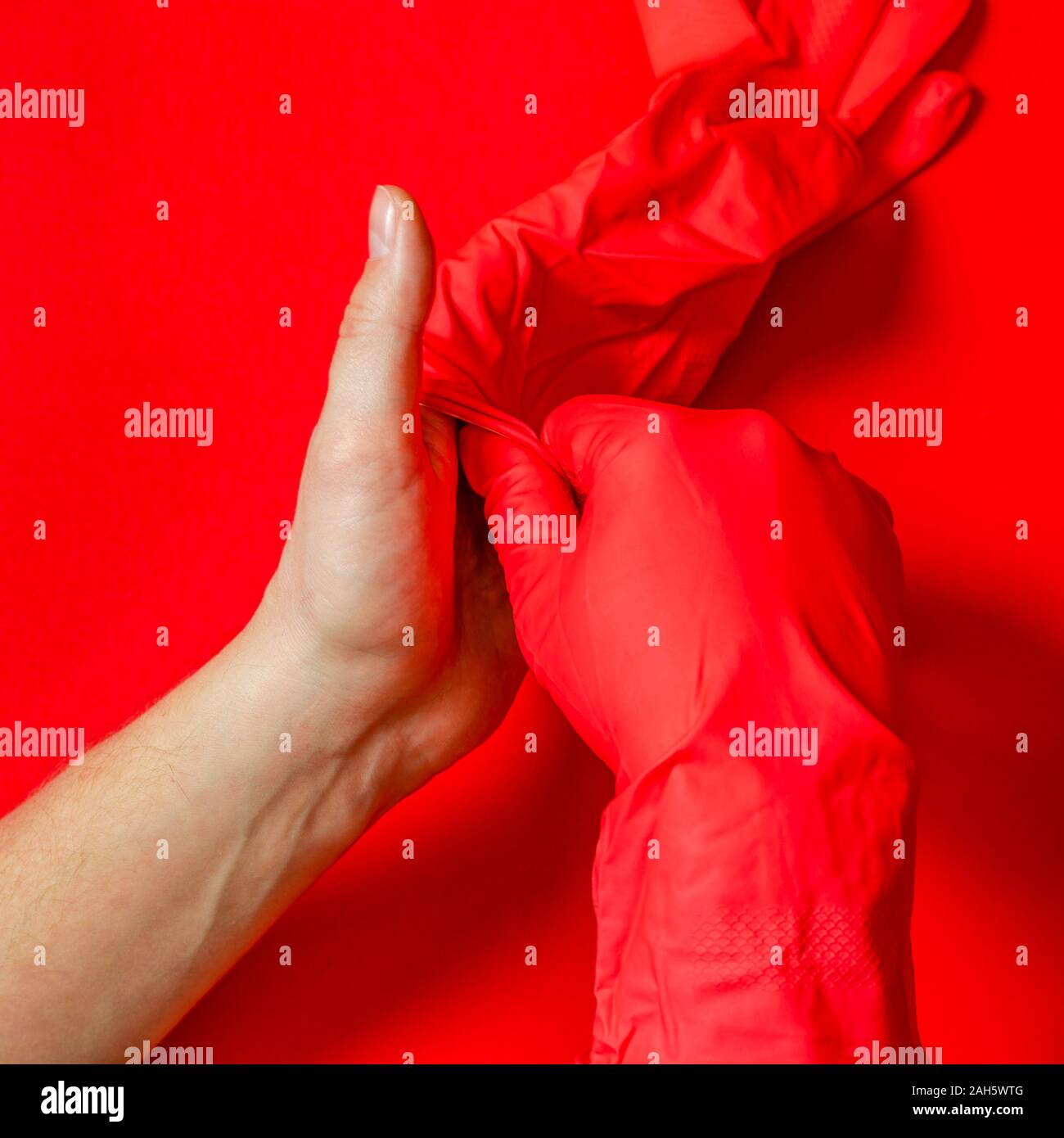 Men's hands wear red rubber gloves before starting work Stock Photo - Alamy