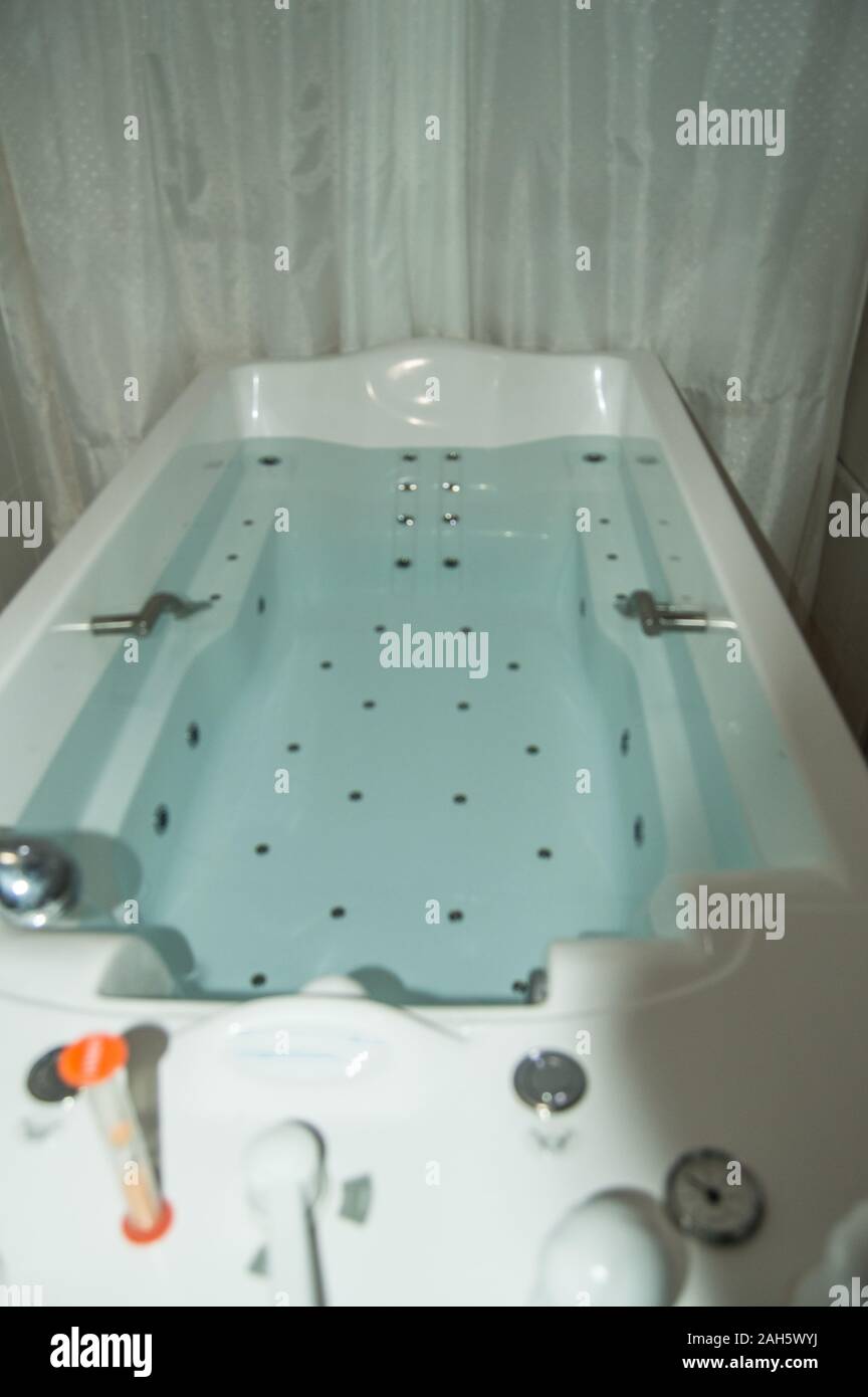 Modern hydro-massage bath filled with water in a balneological resort ...