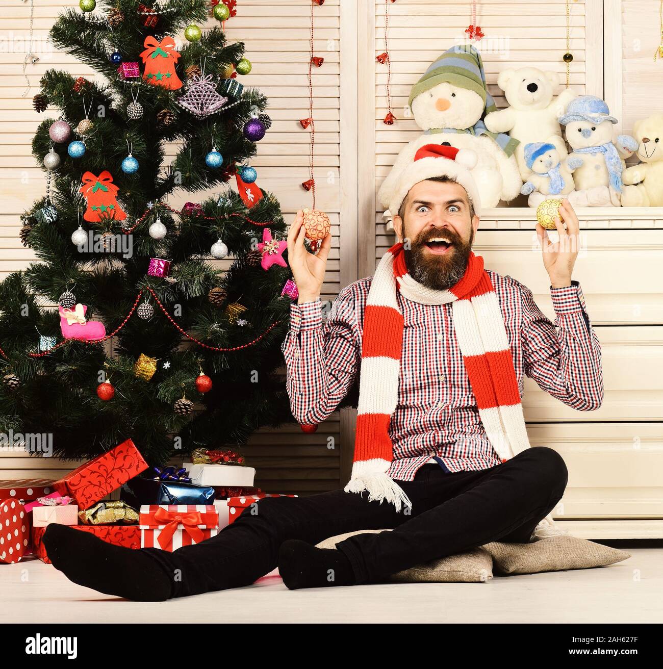 Guy decorates Christmas tree. Celebration and decor concept. Man with ...