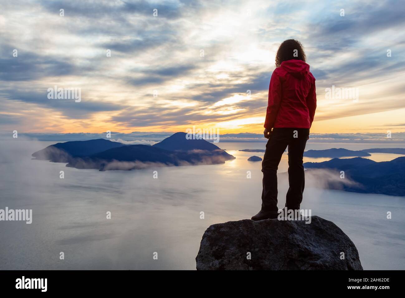 Adventurous Girl on top of a Mountain during Sunset Stock Photo - Alamy