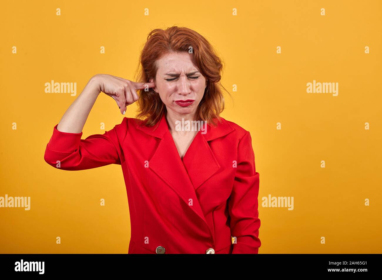 Disappointed caucasian young woman squeezing face, pointing finger at ...