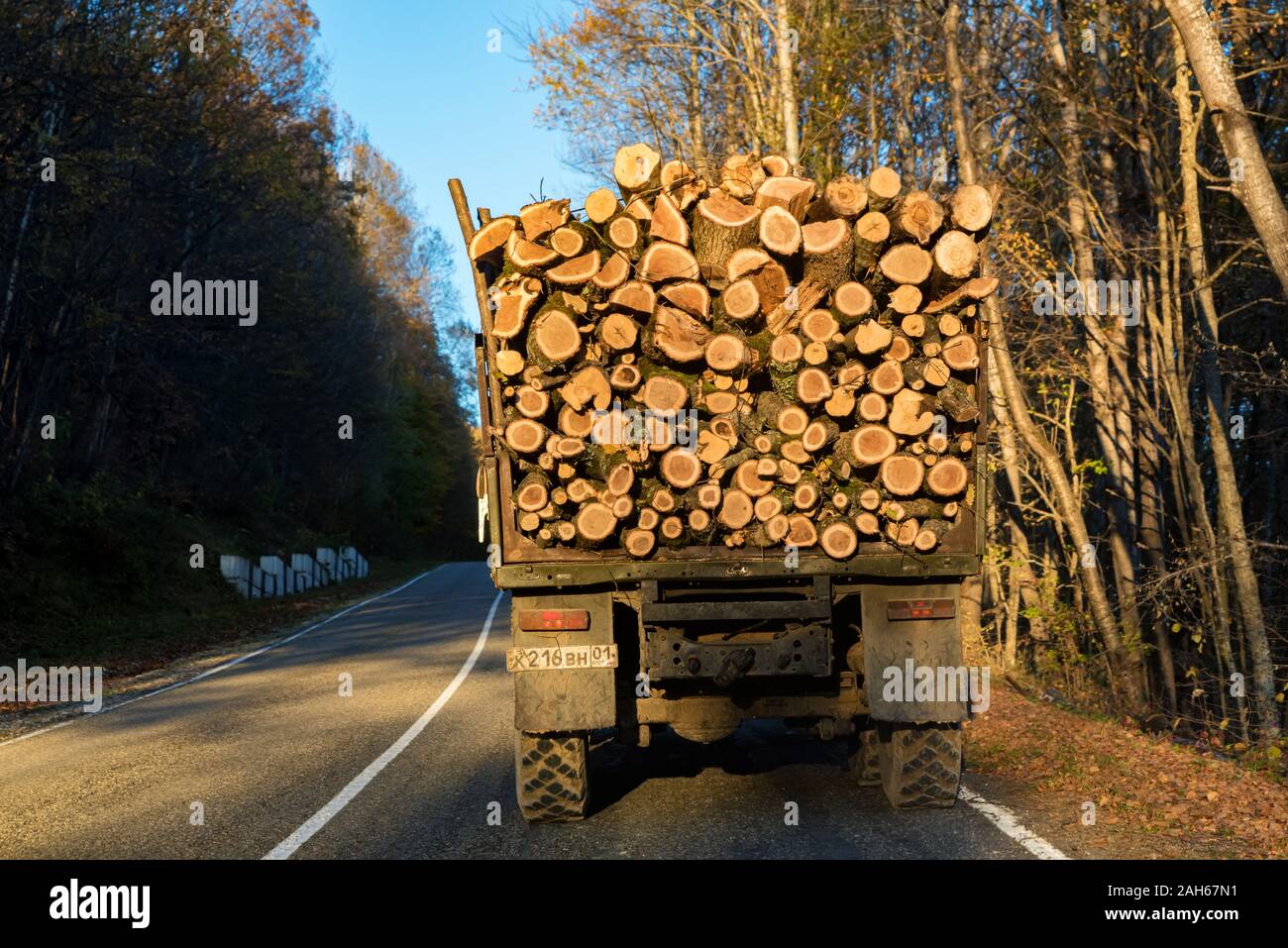 Back view of truck loaded with lumber on bright autumn road Stock Photo ...
