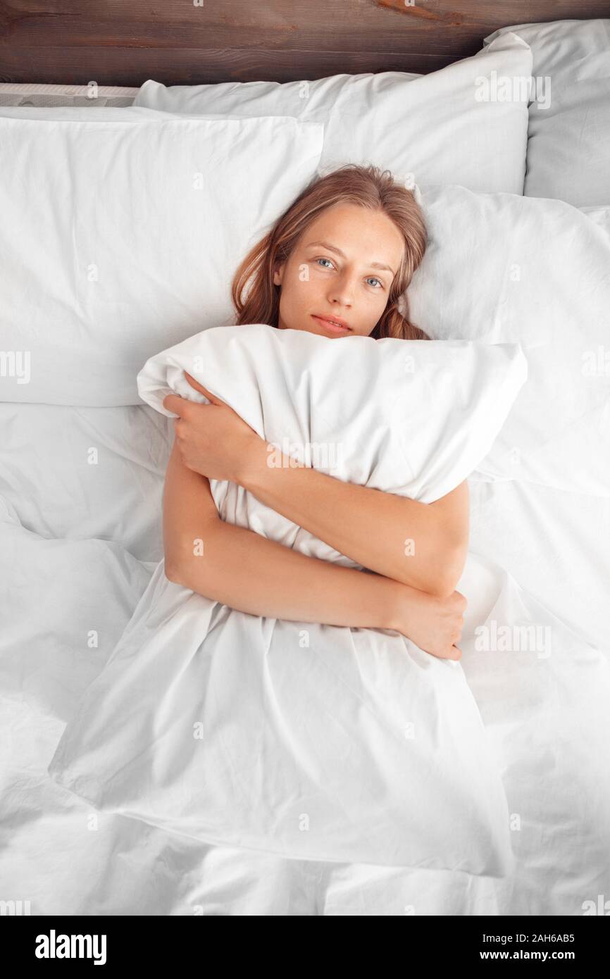 Morning At Home Woman Lying On Bed Hugging Pillow Sleepy Top View