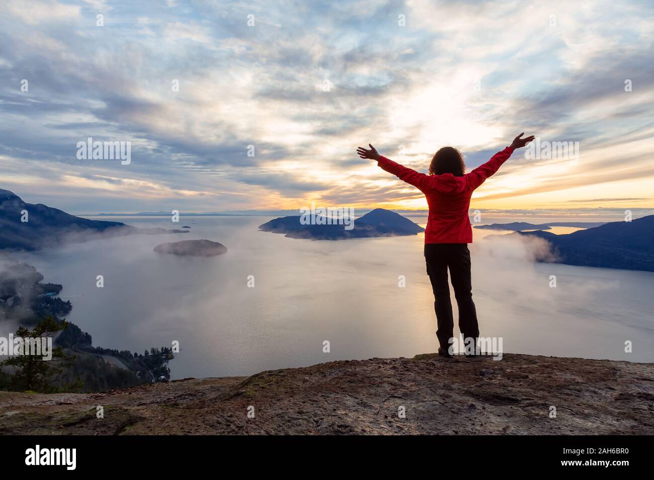 Adventurous Girl on top of a Mountain during Sunset Stock Photo - Alamy