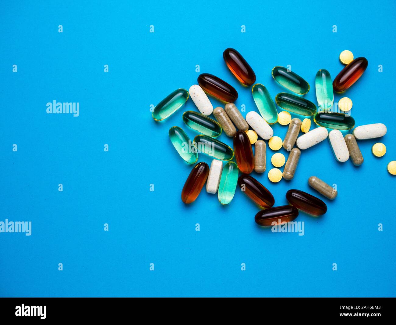 Spilled colored medications and pills on a blue background ...