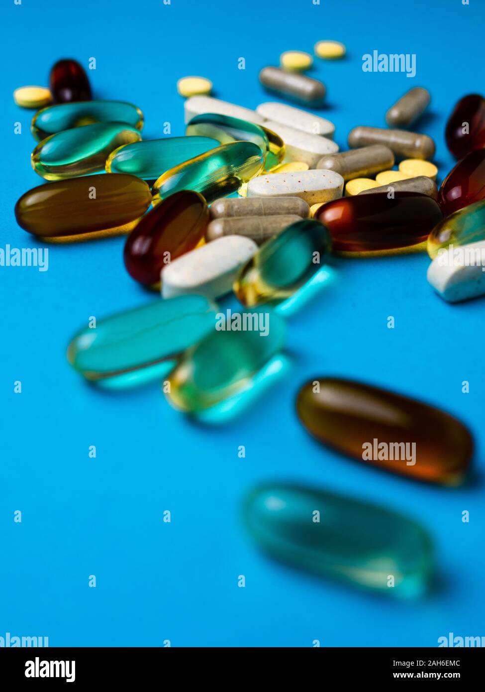 Spilled colored medications and pills on a blue background ...