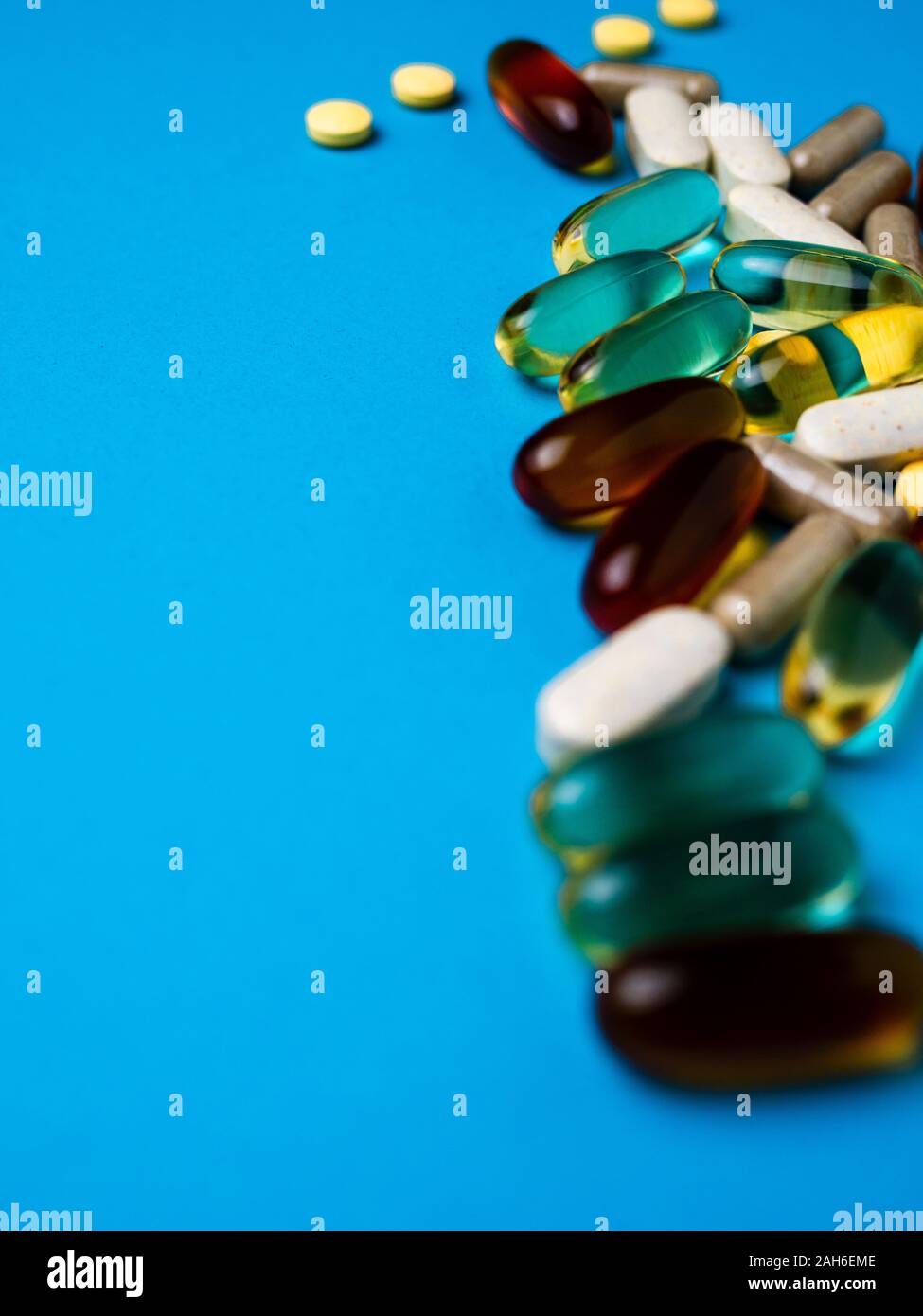 Spilled colored medications and pills on a blue background ...