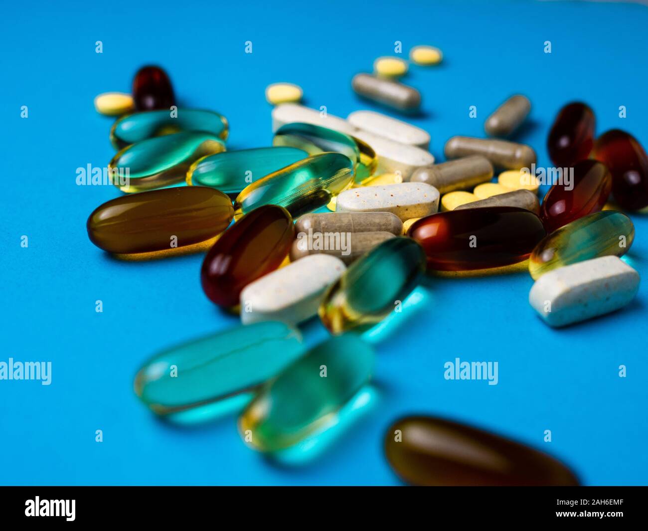 Spilled colored medications and pills on a blue background ...