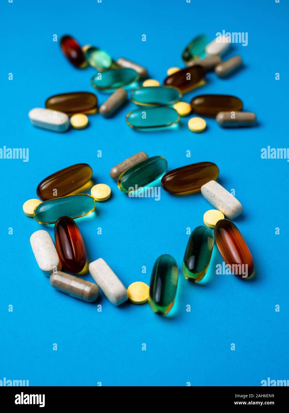 Spilled colored medications and pills on a blue background ...