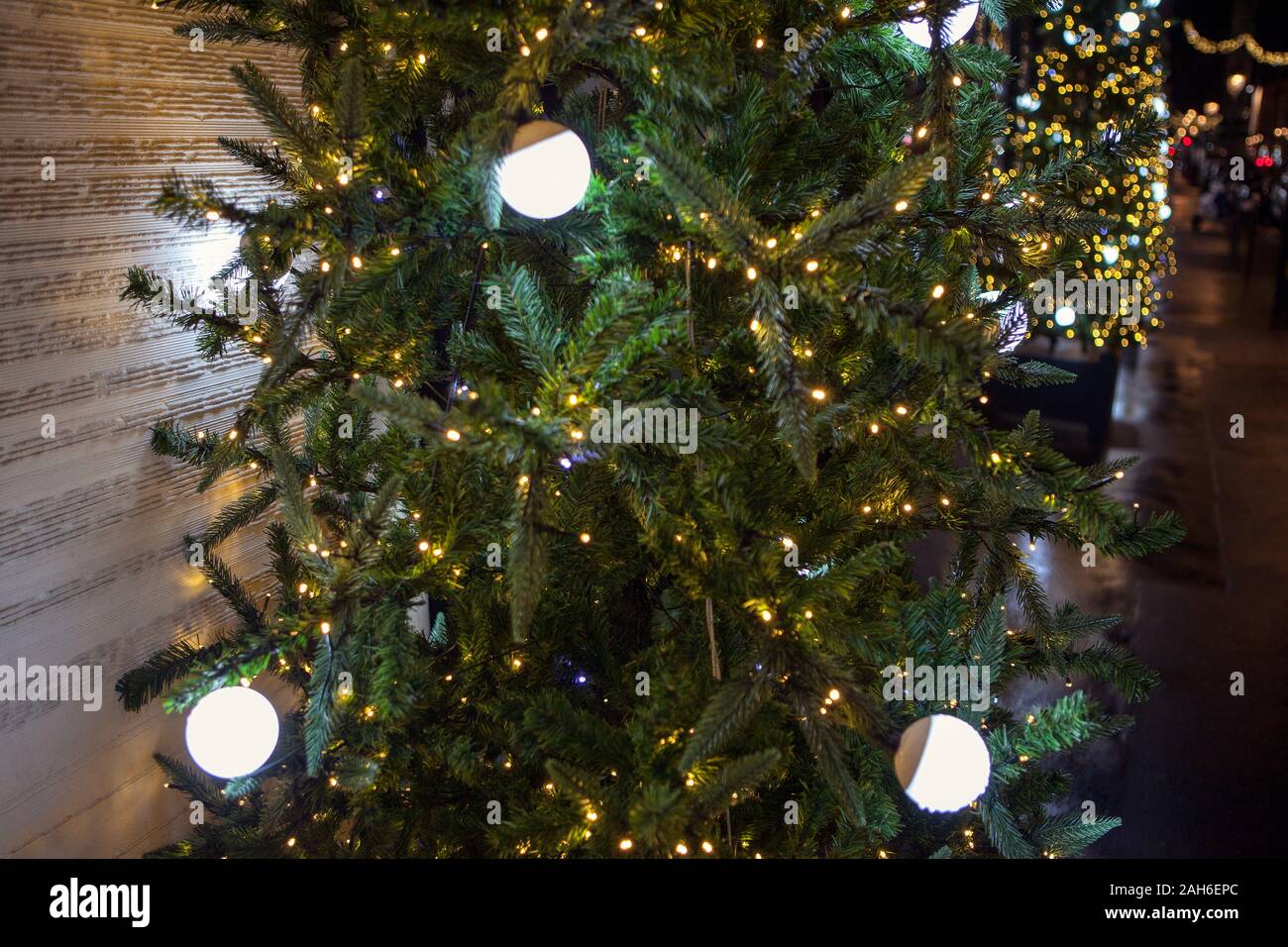 Christmas tree on the street decorated by garlands Stock Photo - Alamy