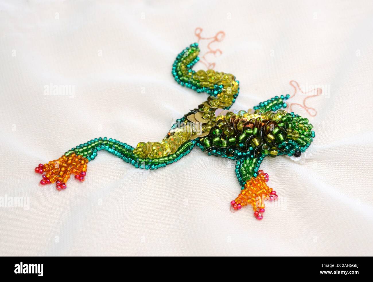 Frog embroidered with beads and sequins on the white cloth Stock Photo ...