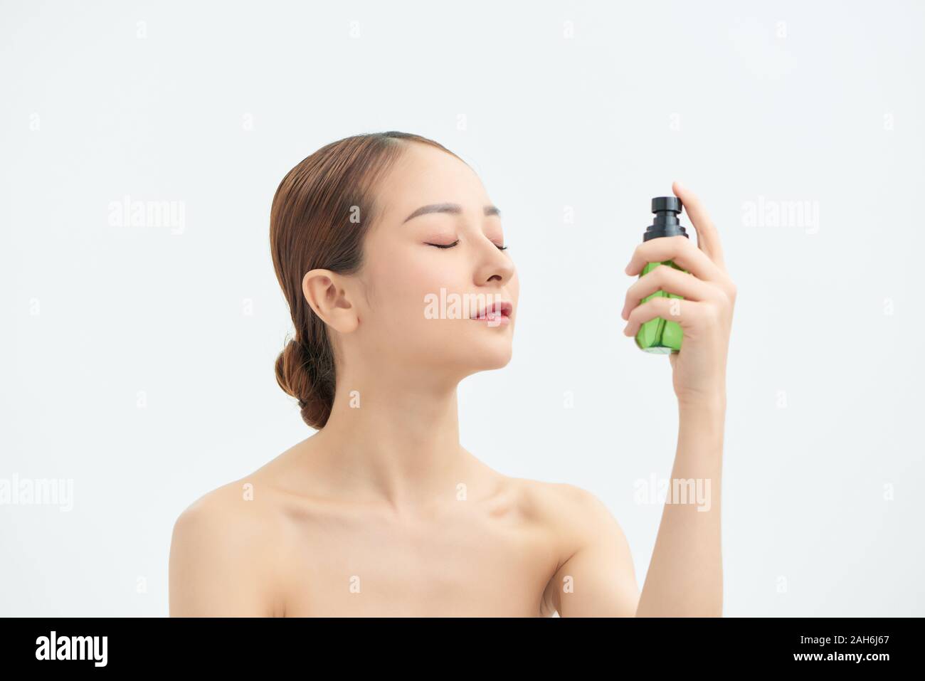 Beautiful asian woman applying spray water on face isolated white ...