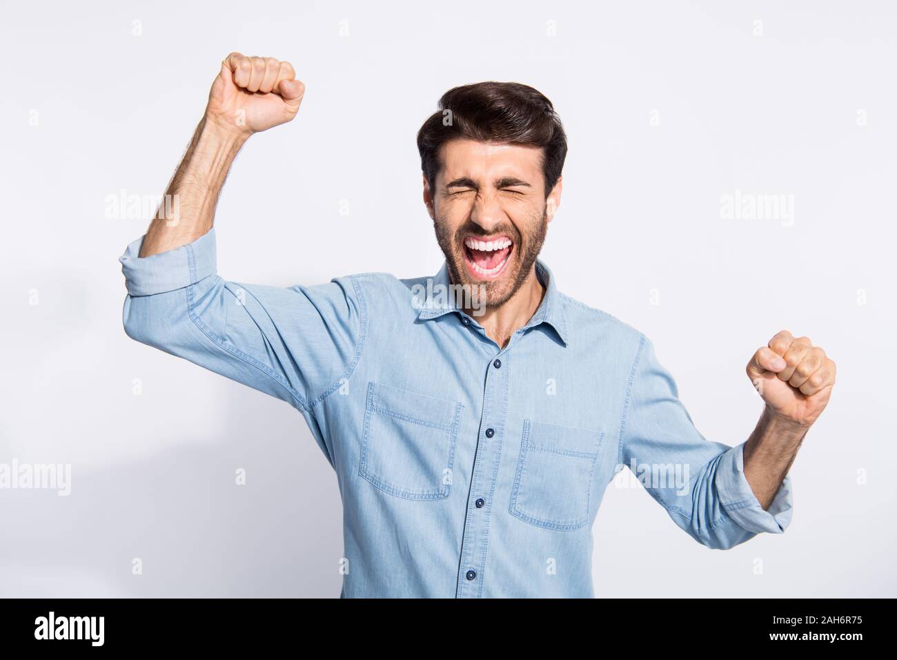 Photo of multiethnic guy celebrating lottery winning raising arms up ...