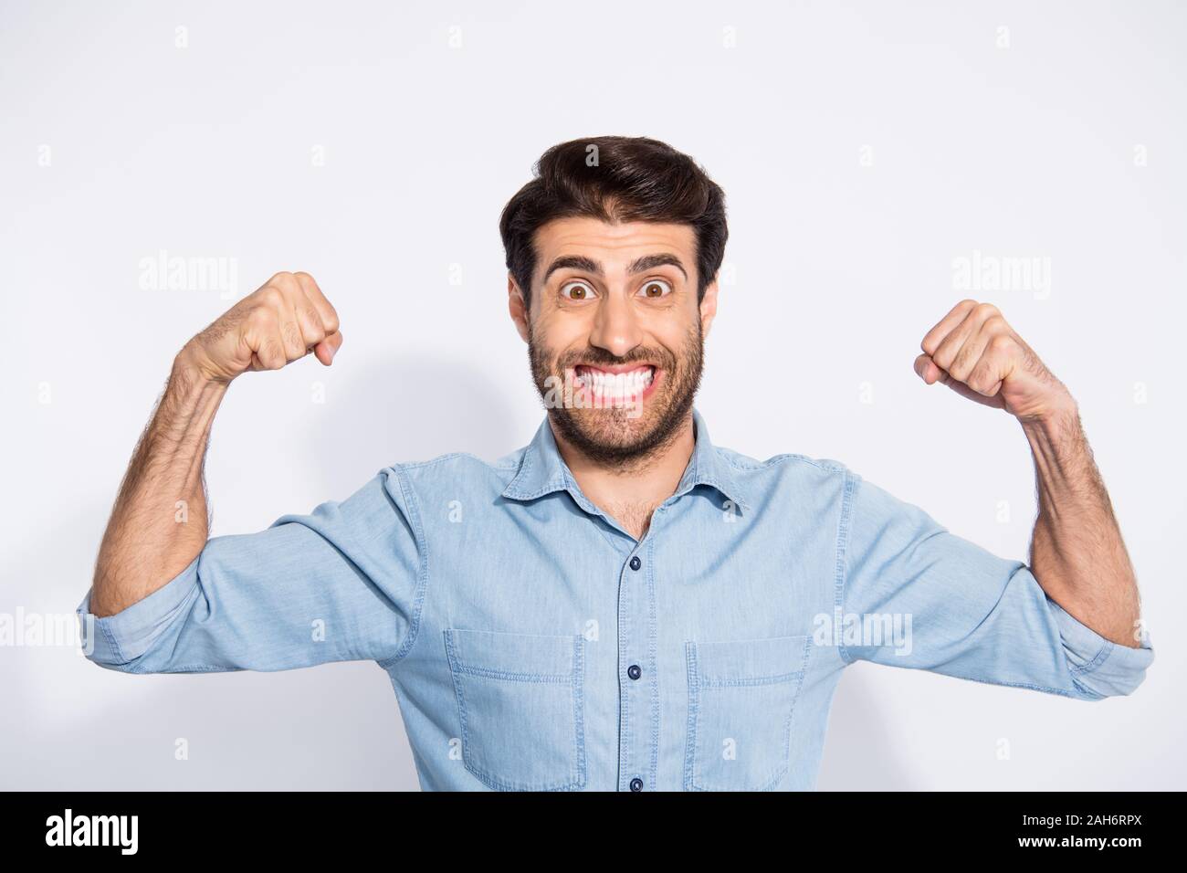 Sport is my life. Photo of amazing handsome guy raising arm showing ...