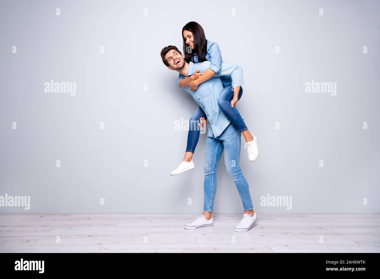 Full size photo of funny guy and lady in piggyback pose walking ...