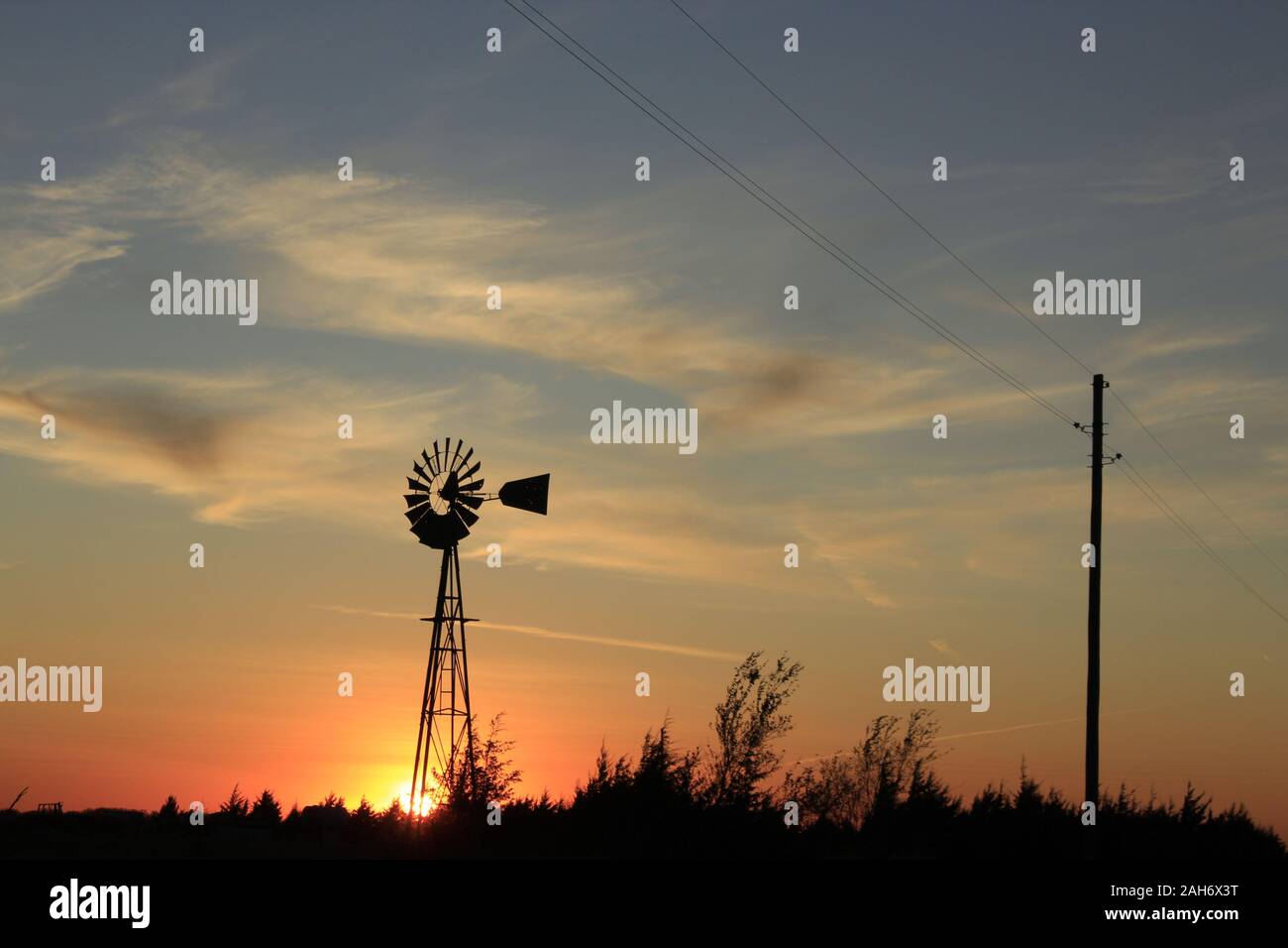 Colorful Kansas Sunset with a yellow and orange sky with a Windmill ...
