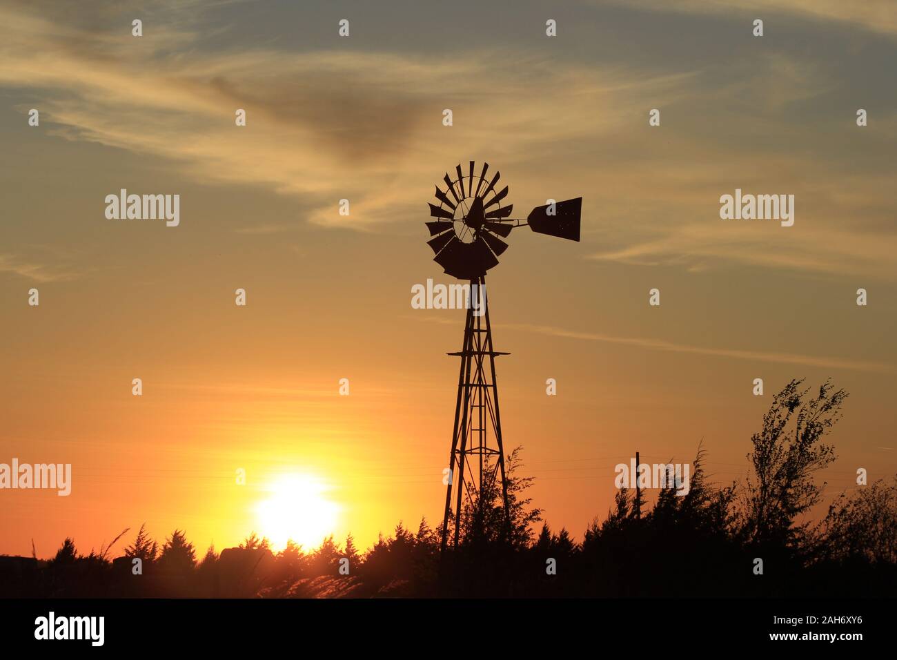 Colorful Kansas Sunset with a yellow and orange sky with a Windmill ...