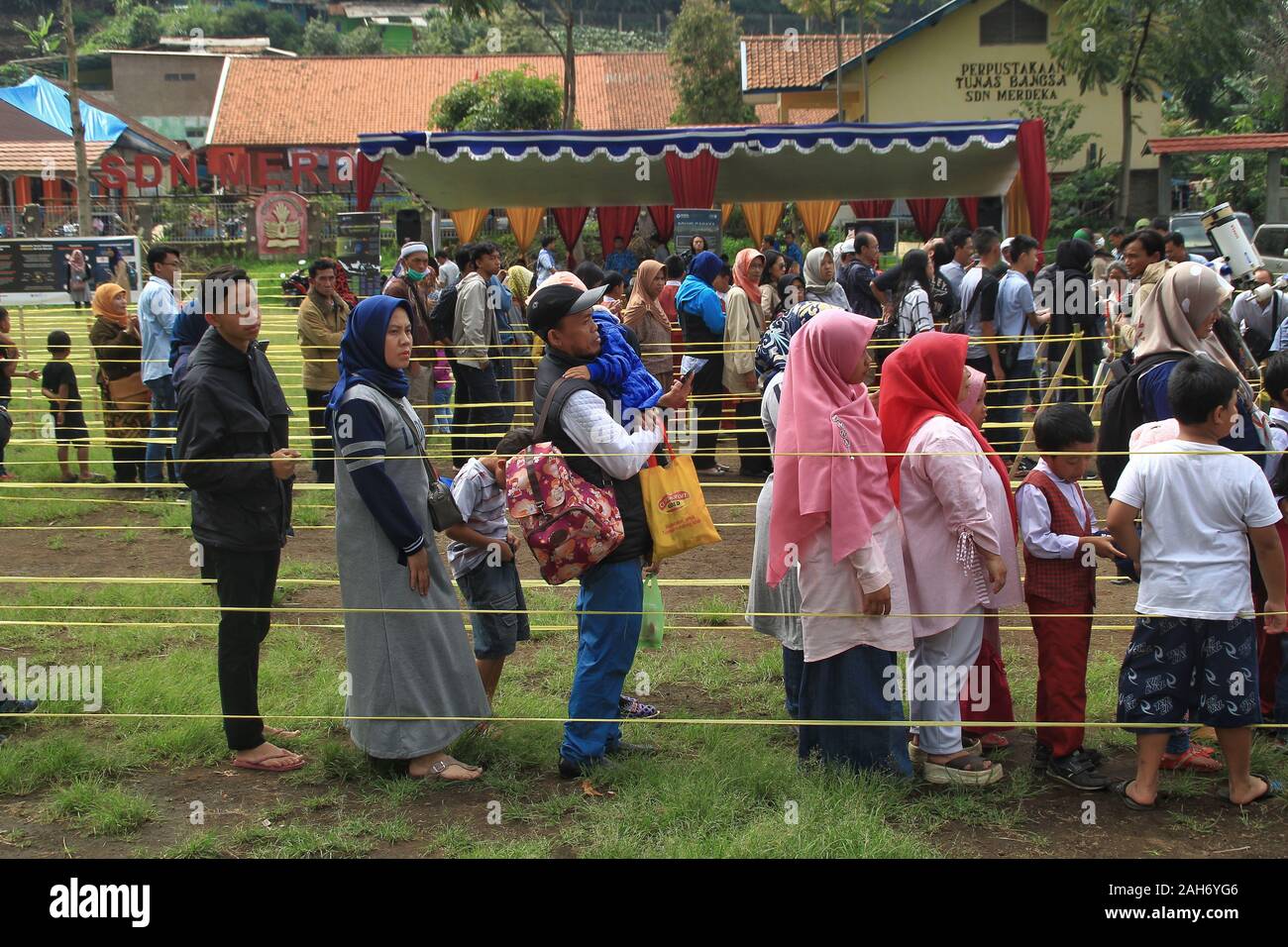 Visitors stand in a queue to observe a ring of solar eclipse using a ...