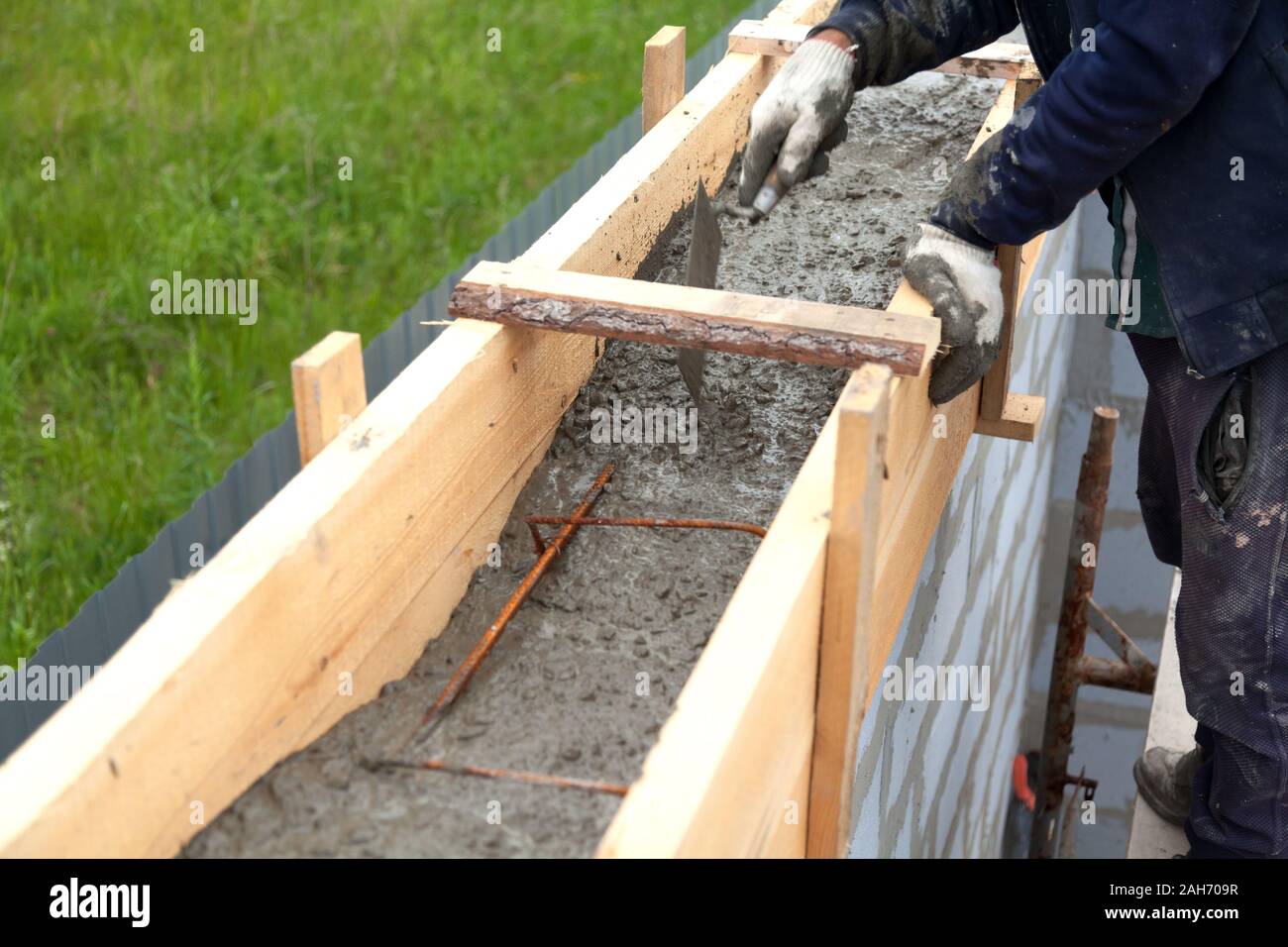 Worker levels concrete in formwork using a trowel Stock Photo - Alamy