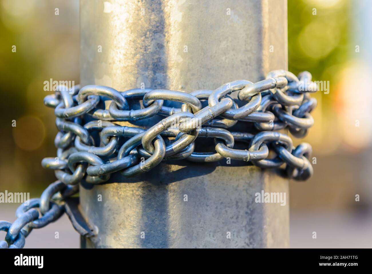 a large metal chain wrapped around the post Stock Photo - Alamy