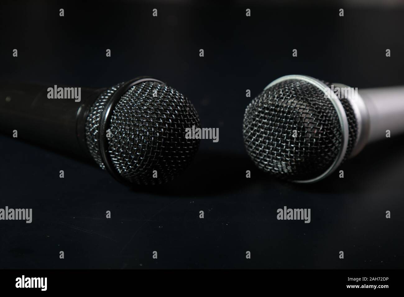 two microphones lie on a black background Stock Photo - Alamy