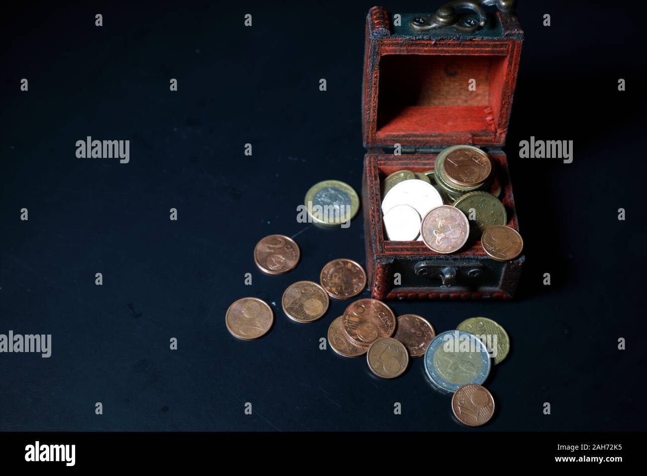 chest with coins on a dark background Stock Photo - Alamy