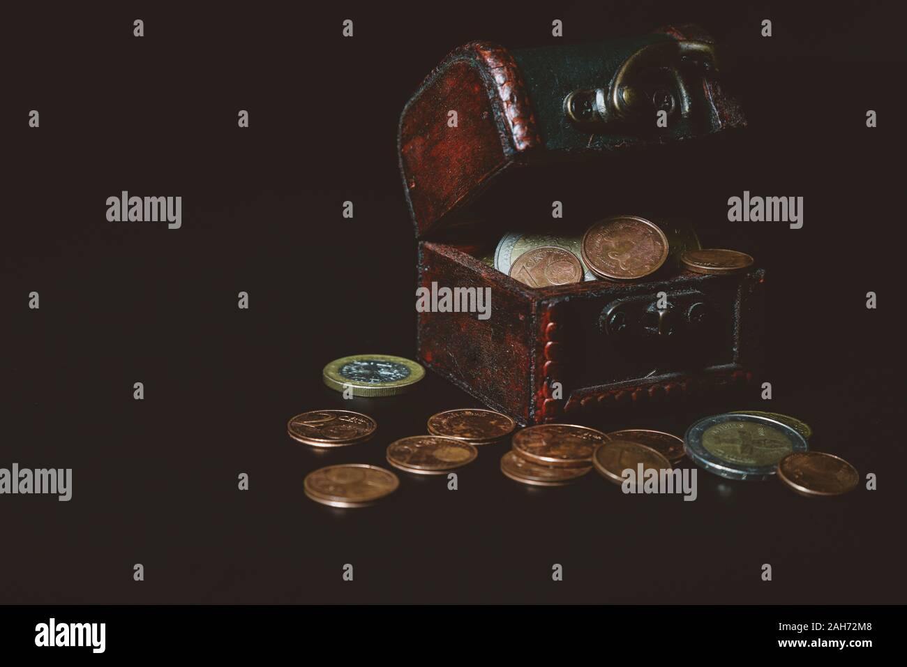 chest with coins on a dark background Stock Photo - Alamy