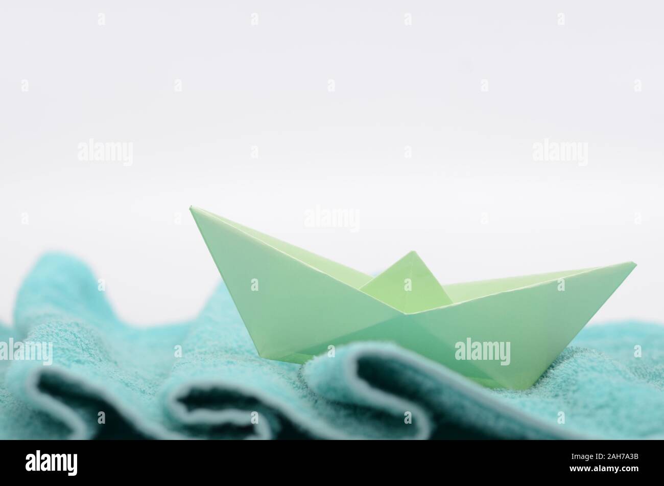 Paper ship sails on woolen fabric waves , hand crafted paper boat on ...