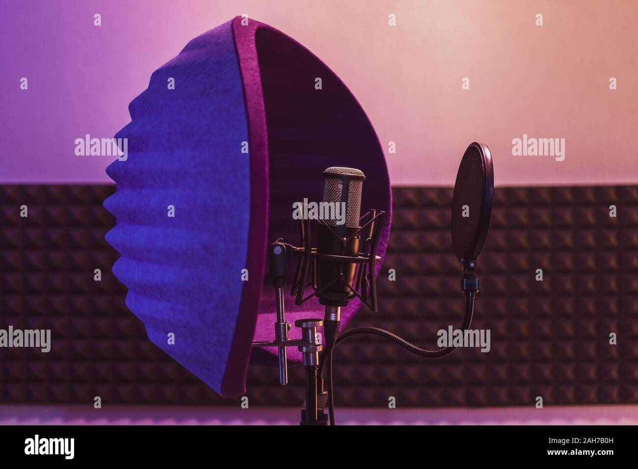 Professional condenser studio microphone on stand with colorful violet ...