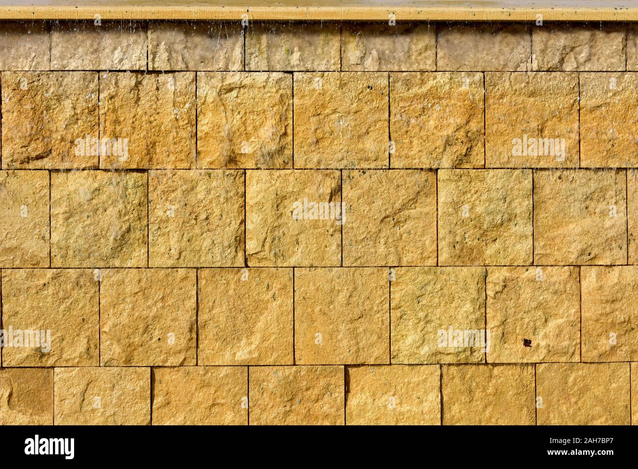 Yellow stone blocks with water flowing background. Yellow stone blocks ...