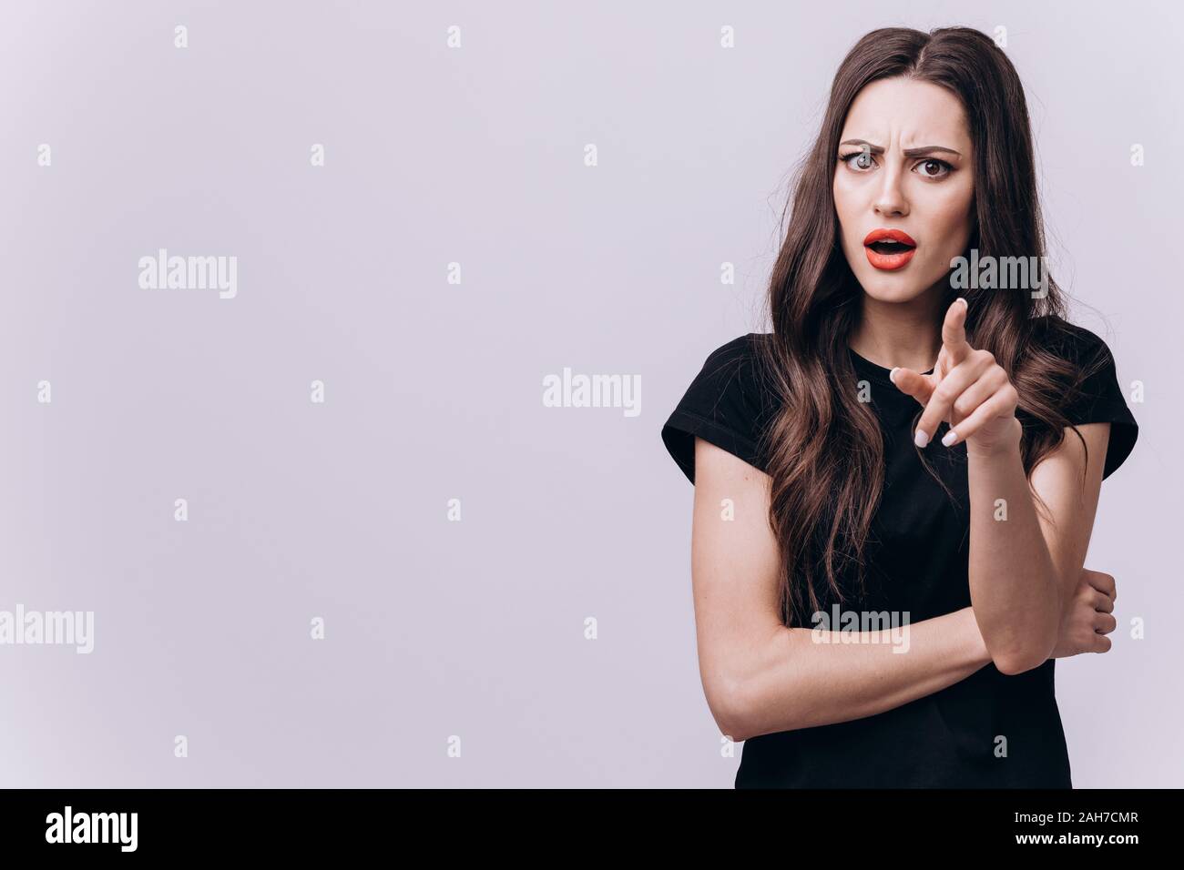 Beautiful surprised woman making a blaming index finger gesture at ...