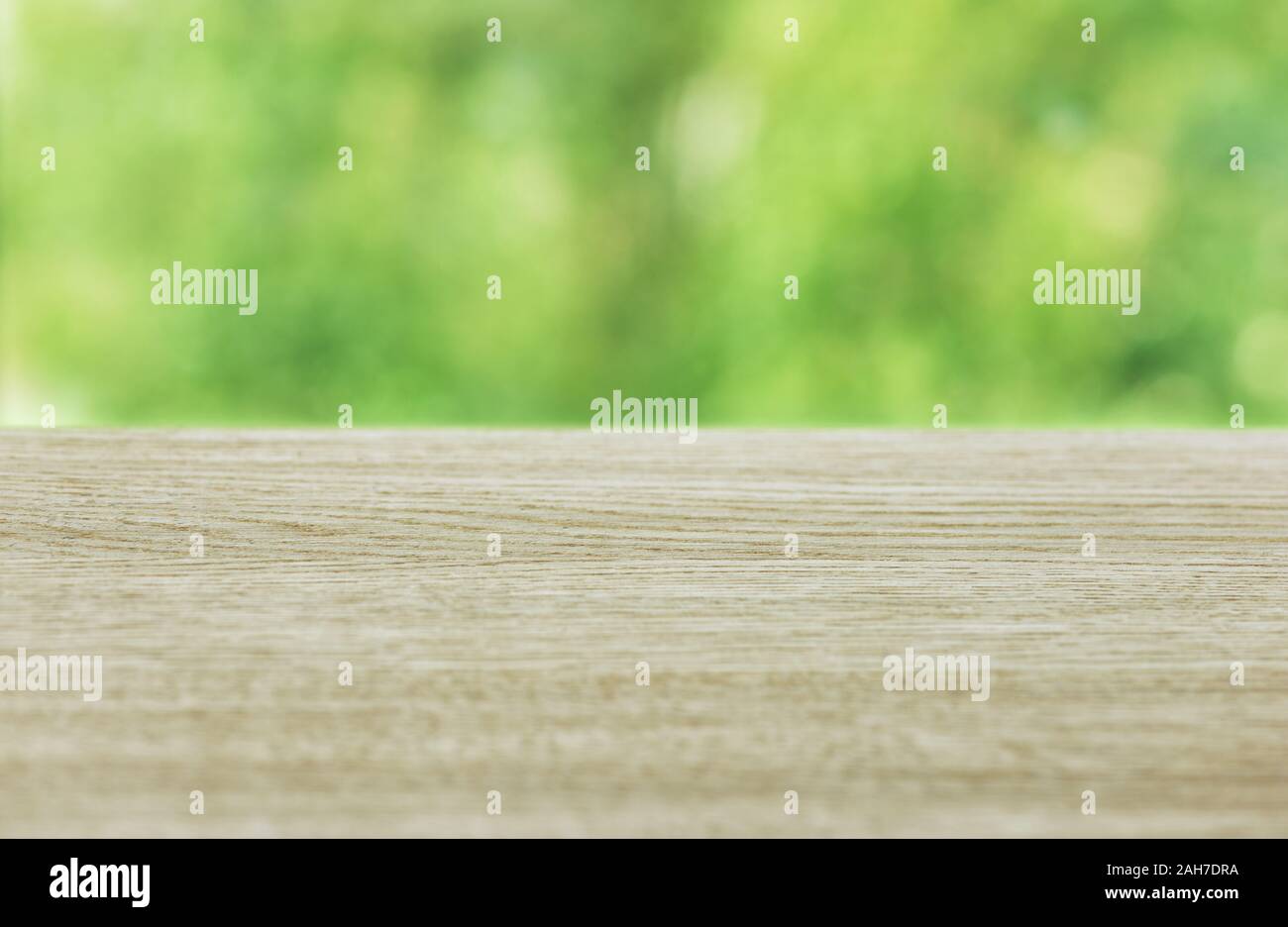 Unpainted surface of natural oak tabletop against a background of green ...