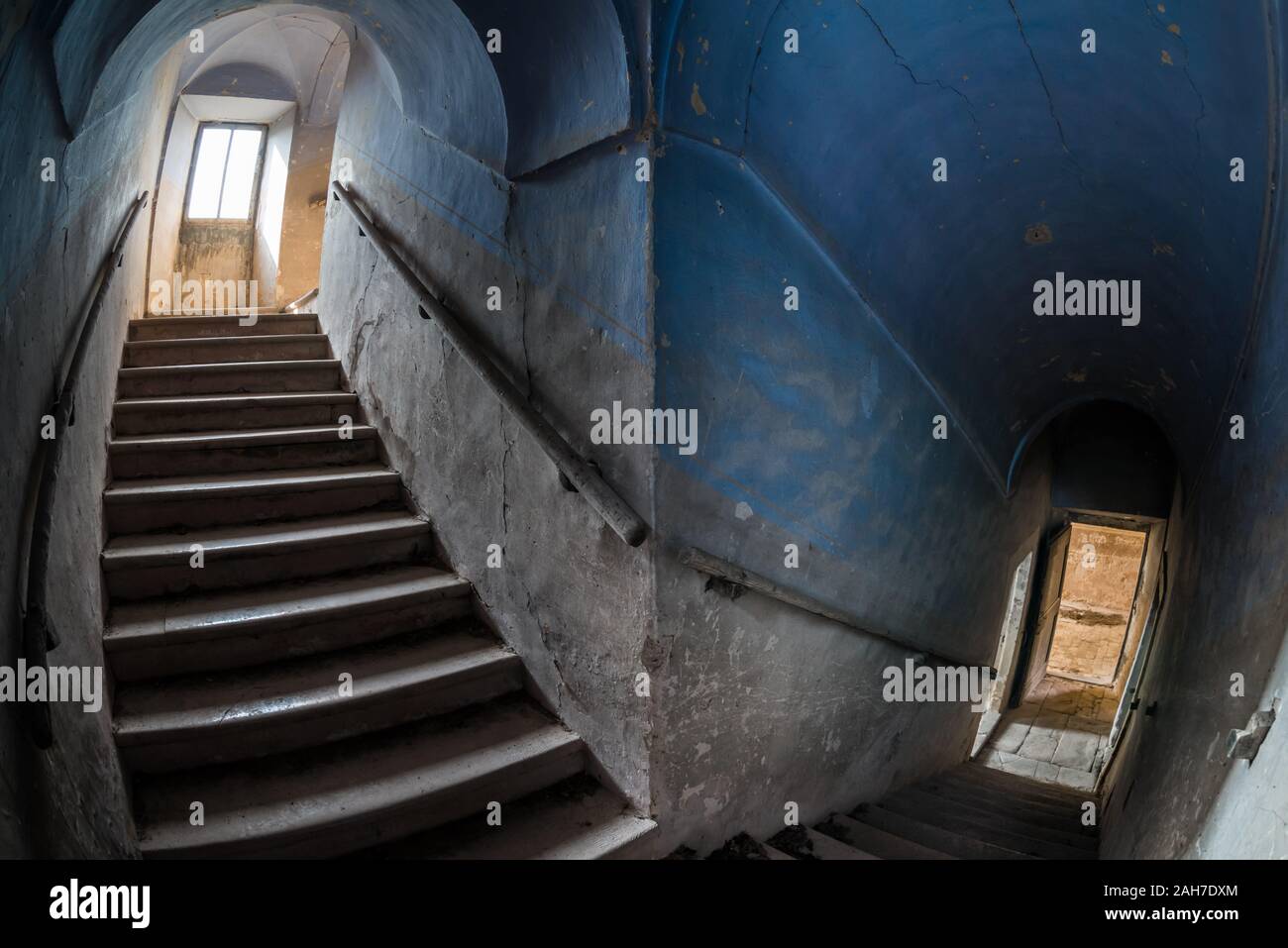 Fisheye view of an ancient monastery stone staircase with blue plaster ...