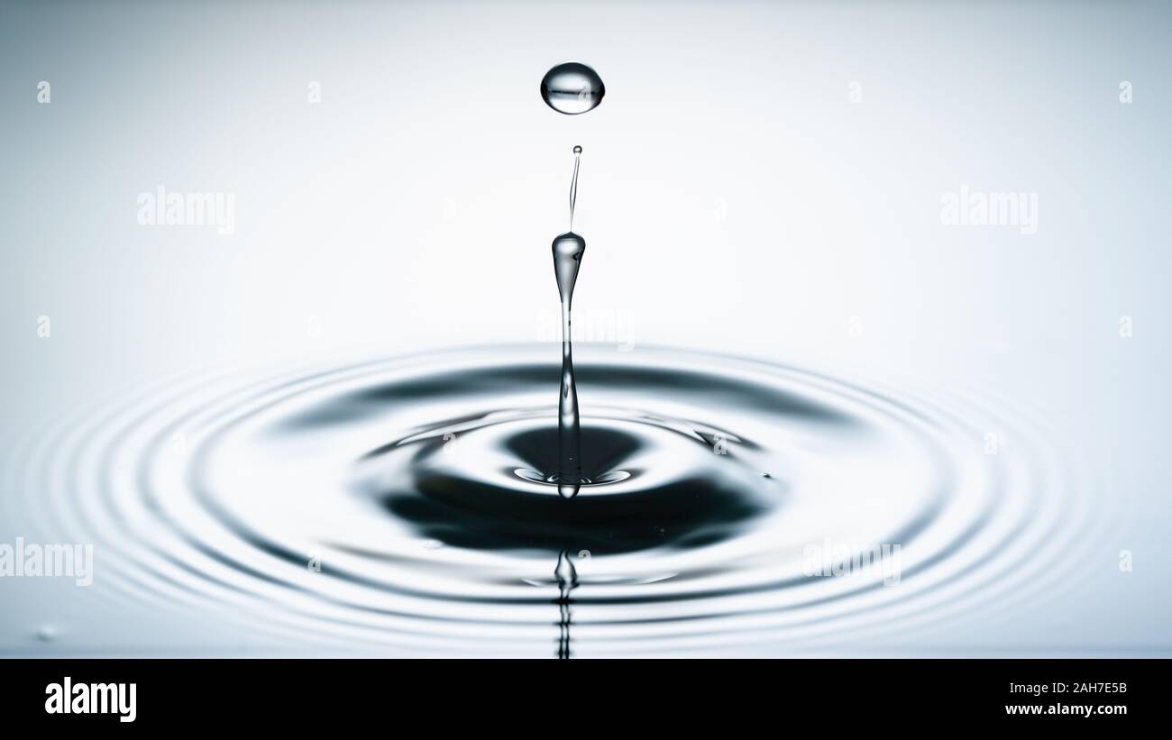 Close-up of a water drop falling on water surface Stock Photo - Alamy