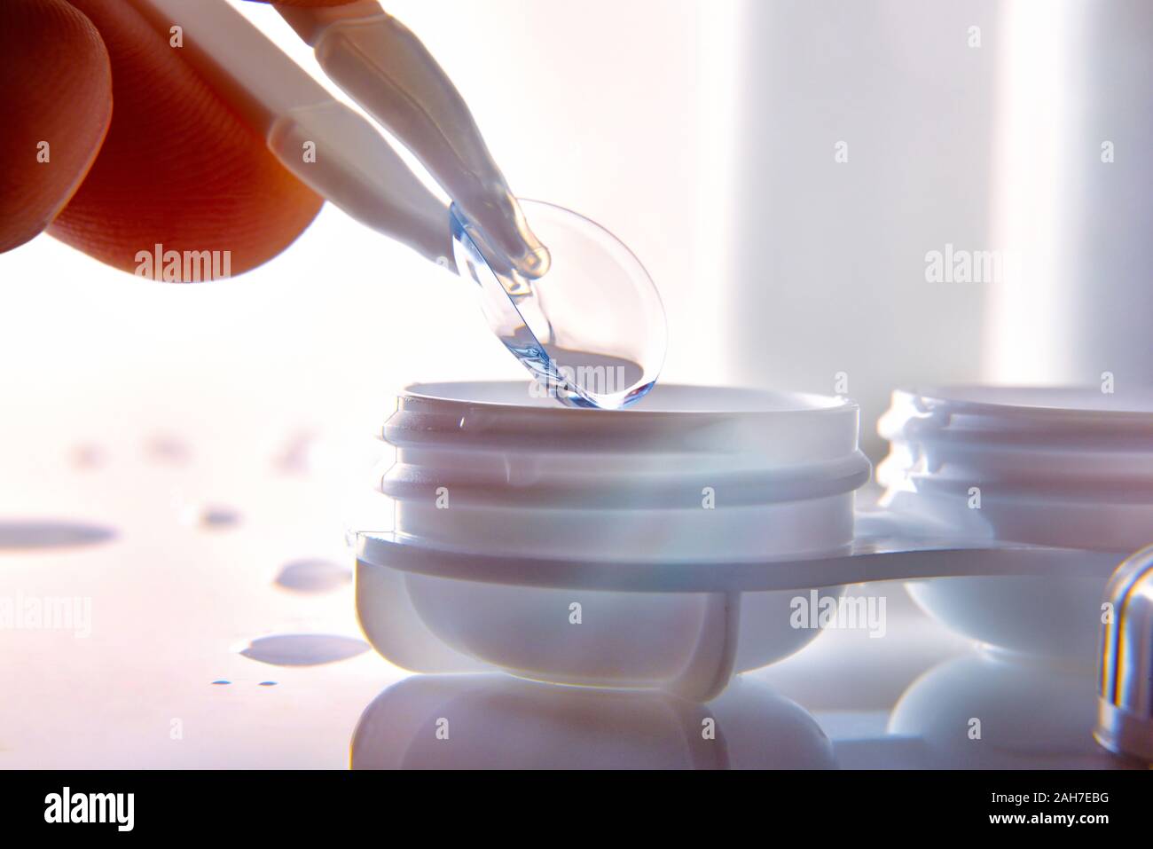 Removing lens from a case with special tweezers. Horizontal composition ...