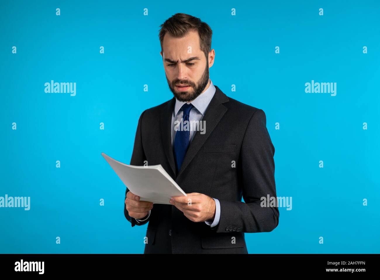 Serious businessman boss isolated on blue background studio. Man is ...