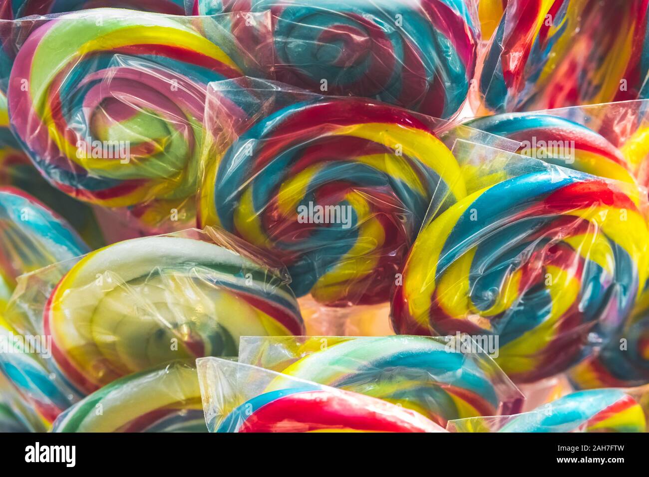 Group of vivid colored lollipops in the display for sale at a candy ...