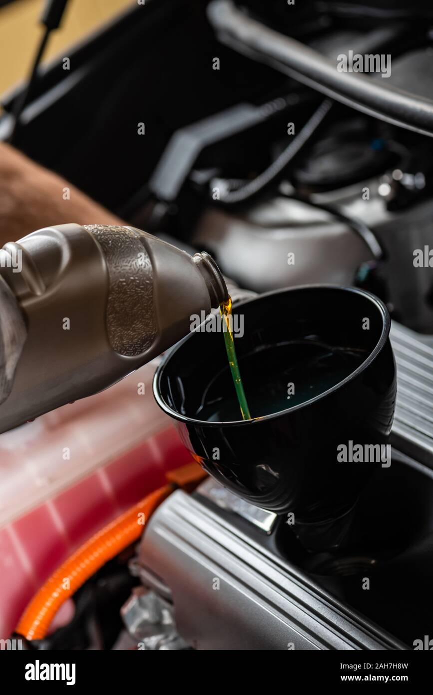 partial view of mechanic pouring motor oil at car engine Stock Photo ...