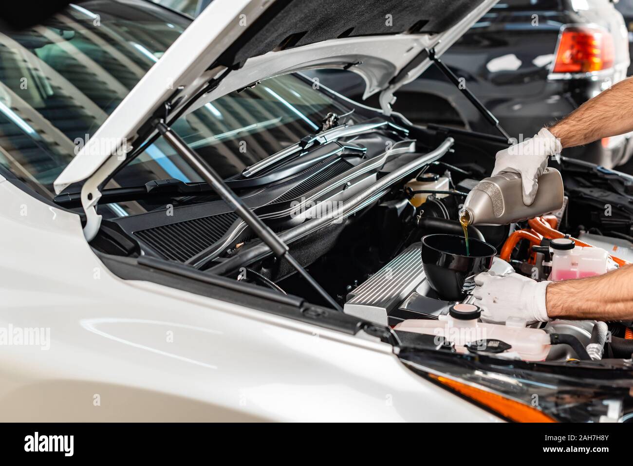partial view of mechanic pouring motor oil at car engine Stock Photo ...