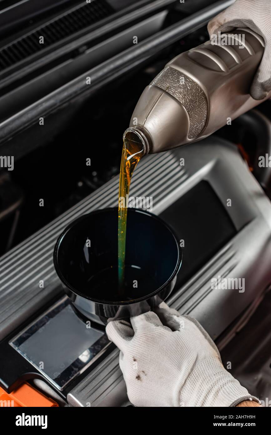 partial view of mechanic pouring machine oil at car engine Stock Photo ...